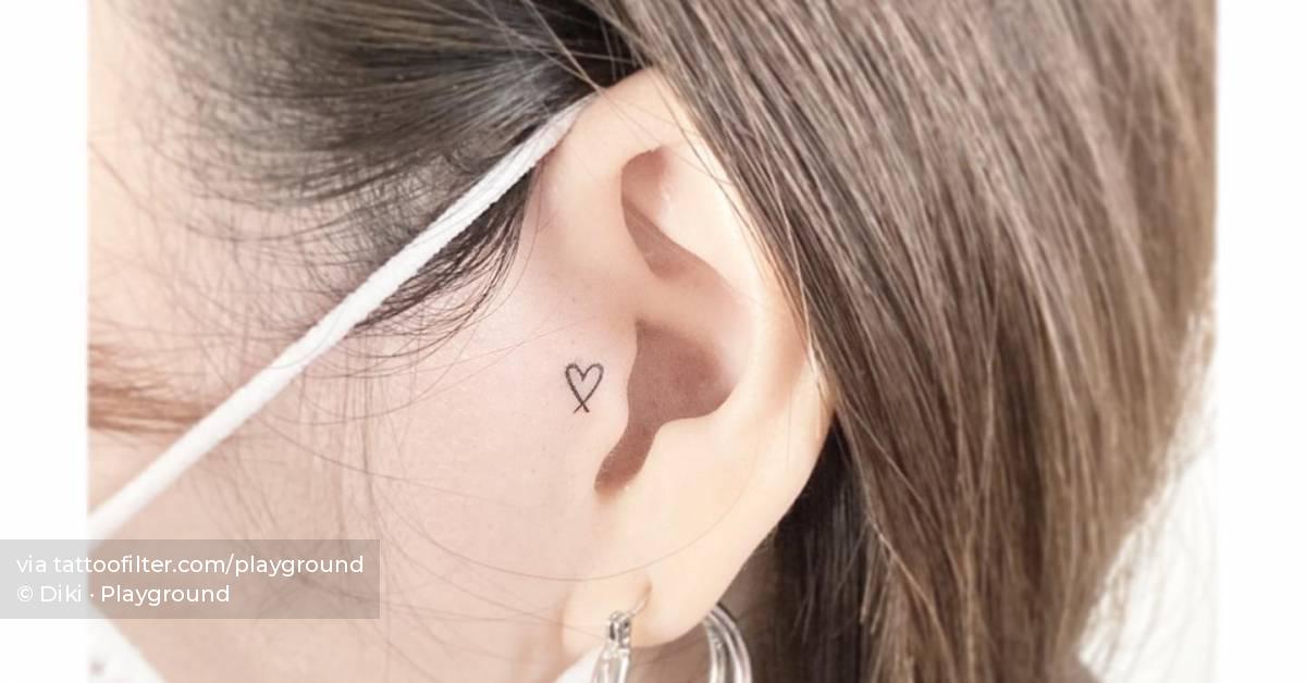 Super tiny heart tattoo placed on the ear, minimalistic