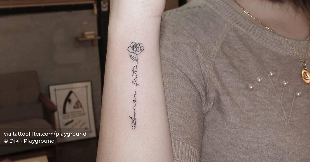 "Amor fati" and rose tattooed on the wrist.