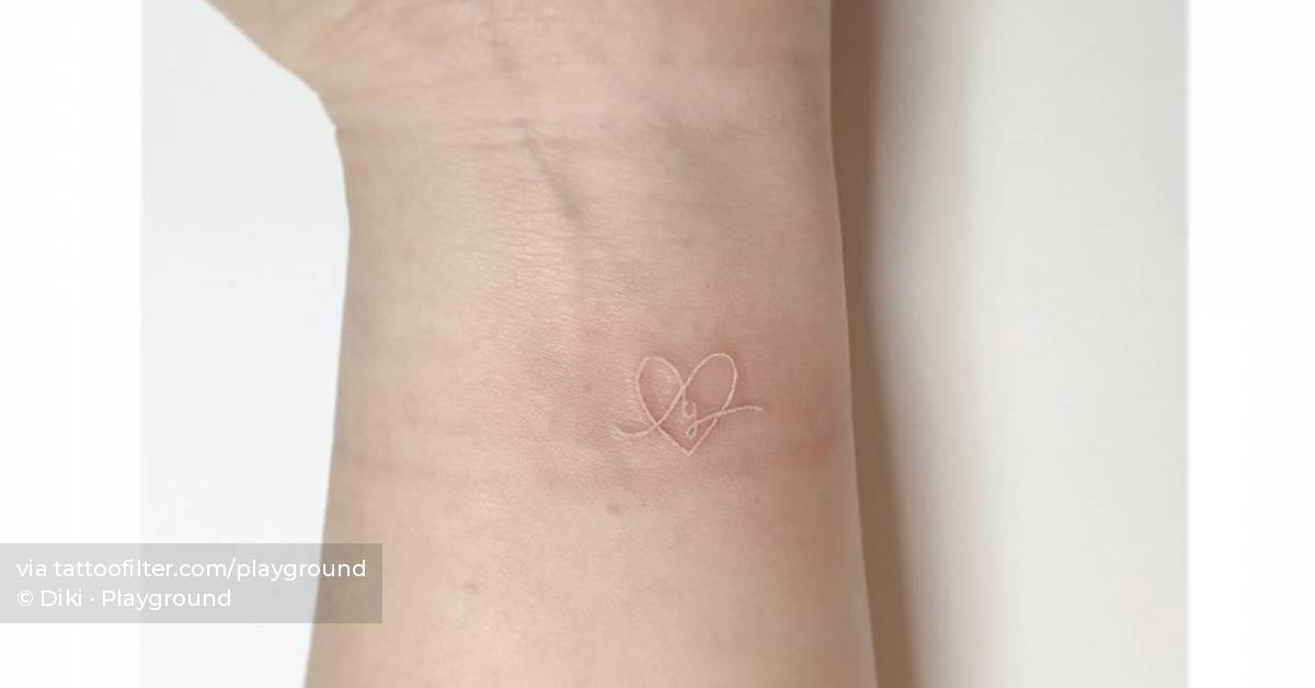 Minimalistic heart and letter "G" tattoo done in white