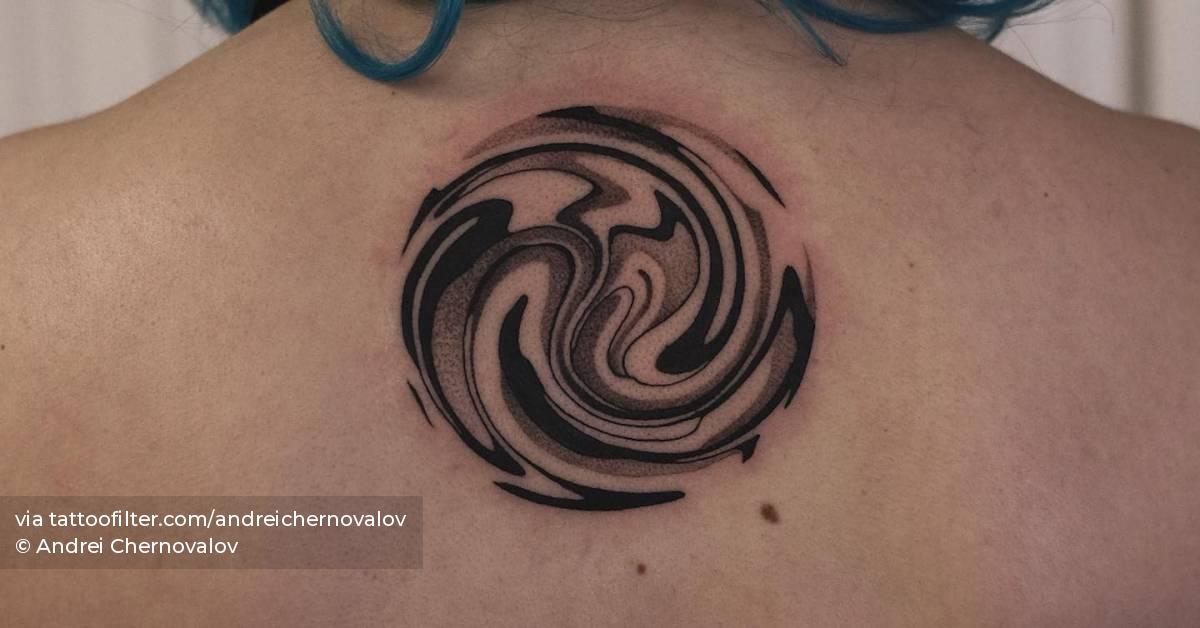 Abstract circle tattooed on the upper back.