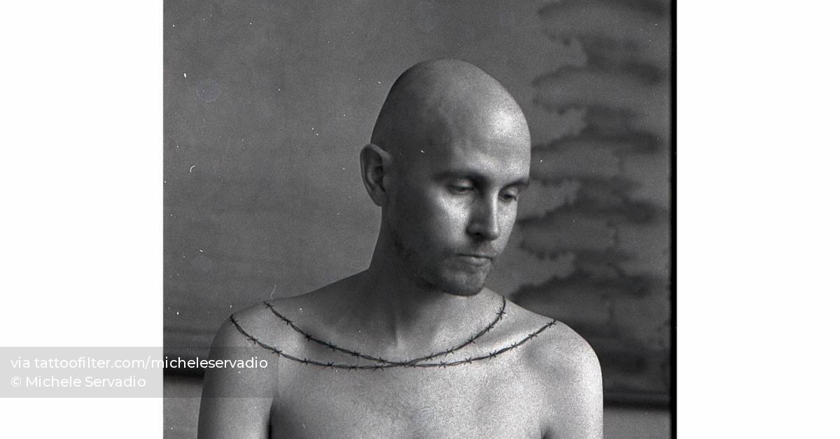 Barbed wire tattoo located around the shoulders.