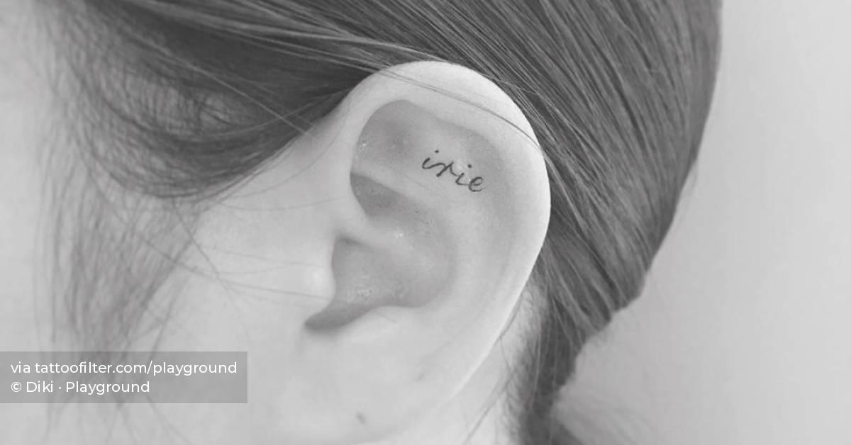 Tattoo of the word "irie" handwritten on the ear.