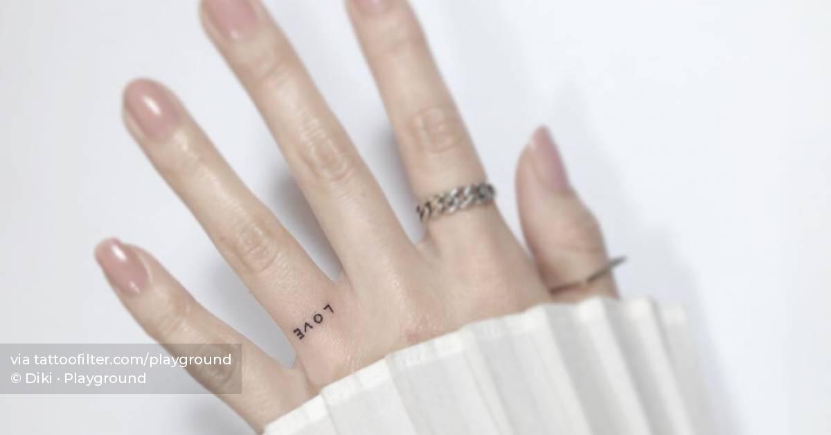 Tiny tattoo of the word "love" placed on the finger.
