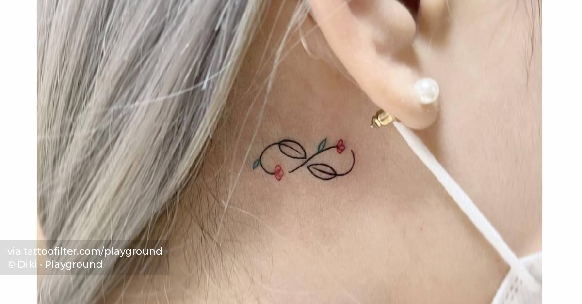 Infinity flower tattoo located behind the ear.