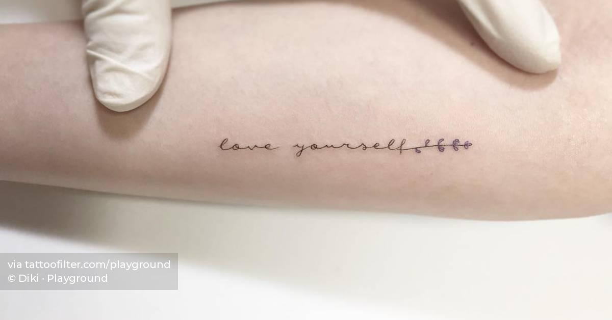 "Love yourself" and little flower tattooed on the inner