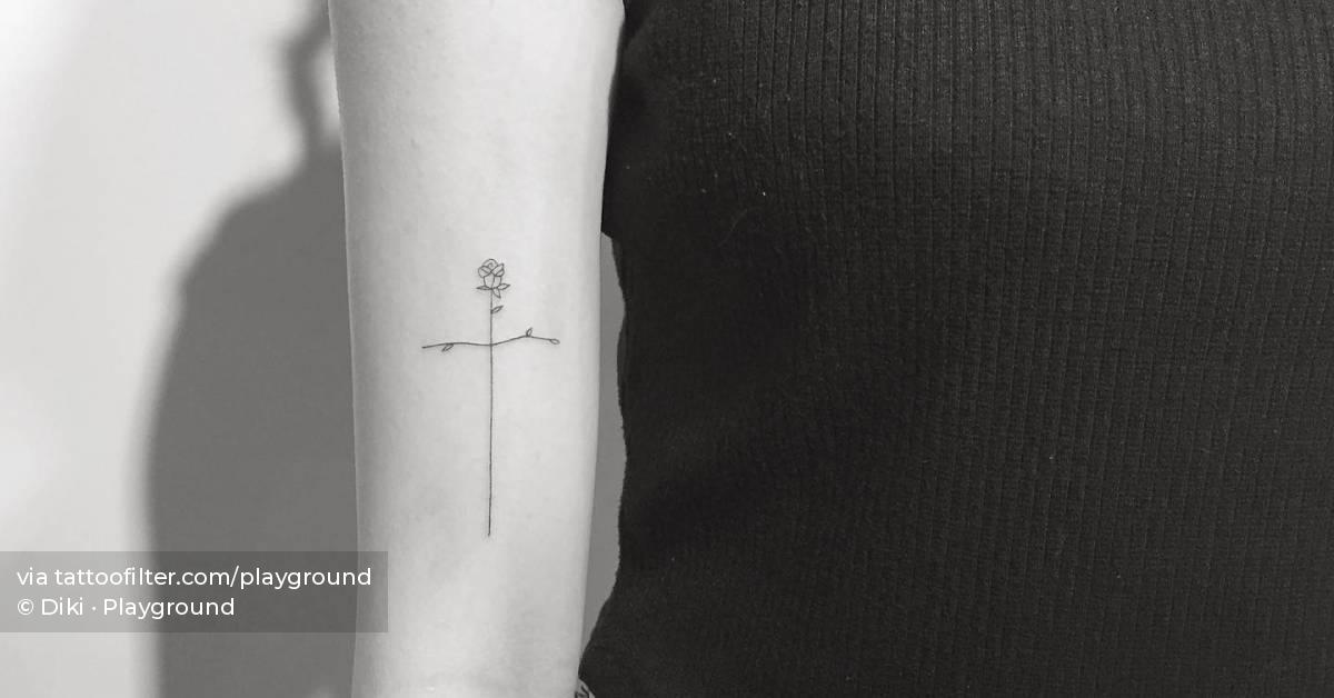 Fine line flower cross tattoo done on the bicep,