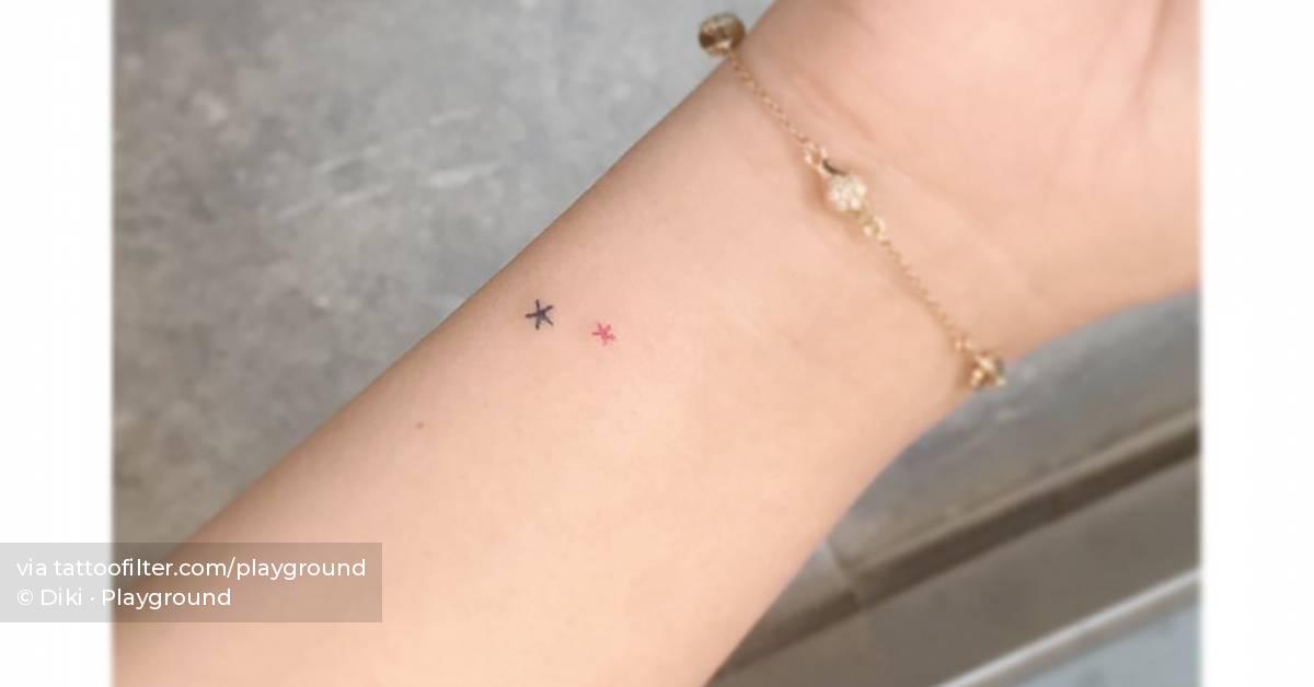 Micro stars tattooed on the wrist, minimalistic style.