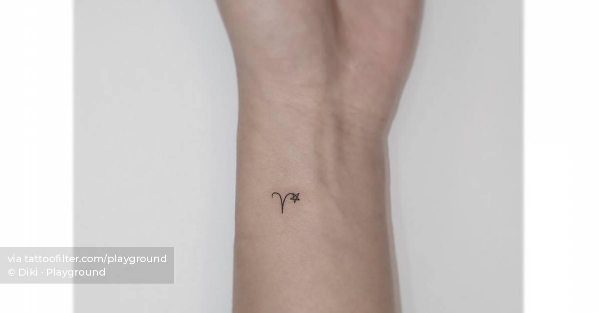 Minimalistic Aries zodiac symbol tattooed on the wrist.