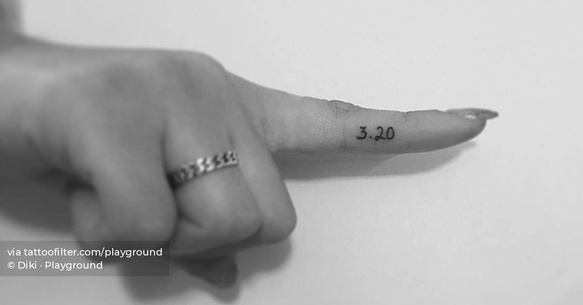 "3.20" lettering tattoo located on the finger.