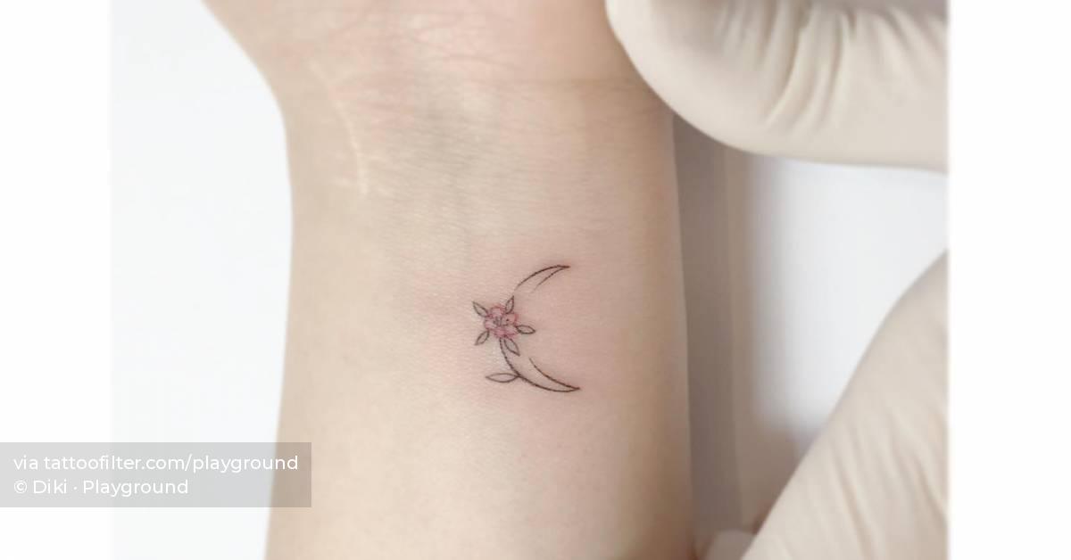 FIne line style flower moon tattoo done on the wrist.