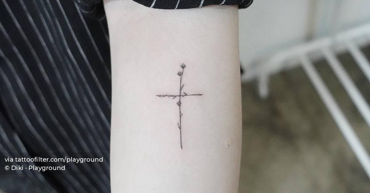 Fine line style flower cross tattoo located on the