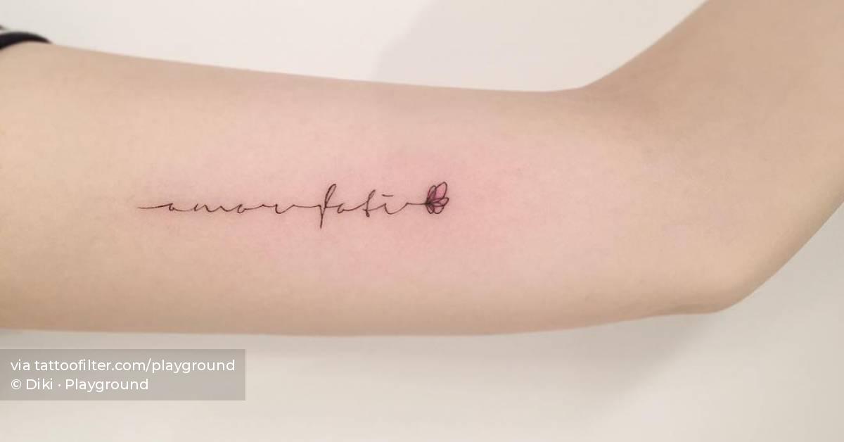 "Amor fati" lettering tattoo locate on the inner arm.