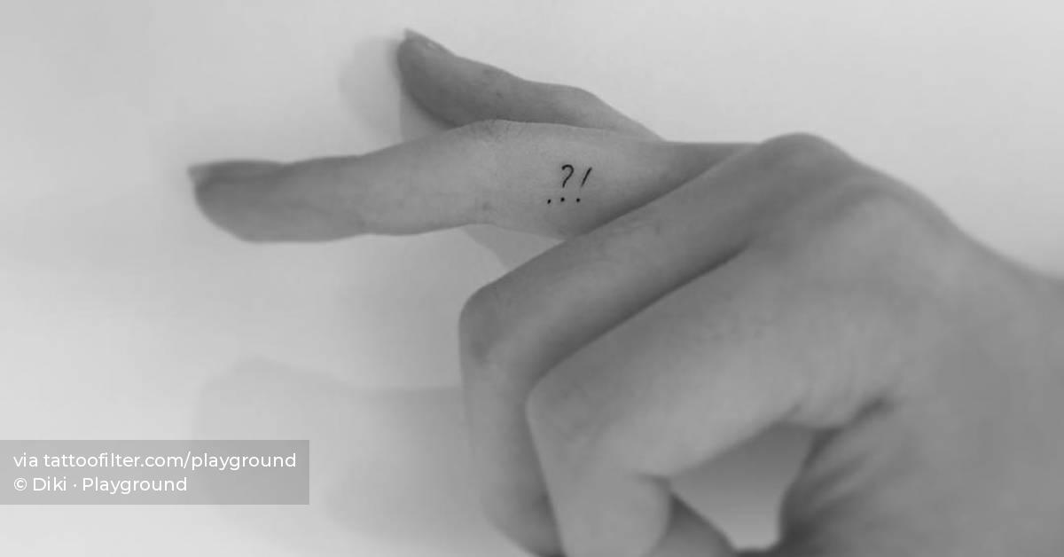 Punctuation marks tattooed on the finger, minimalistic