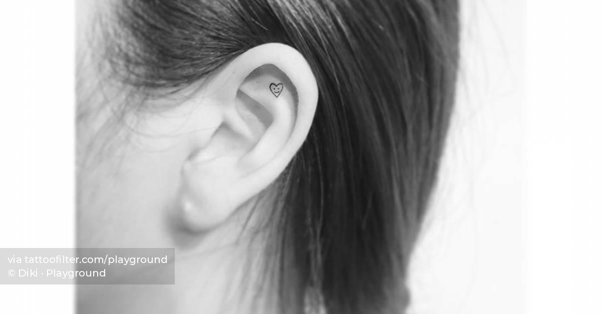 Micro smiley heart tattoo located on the ear.