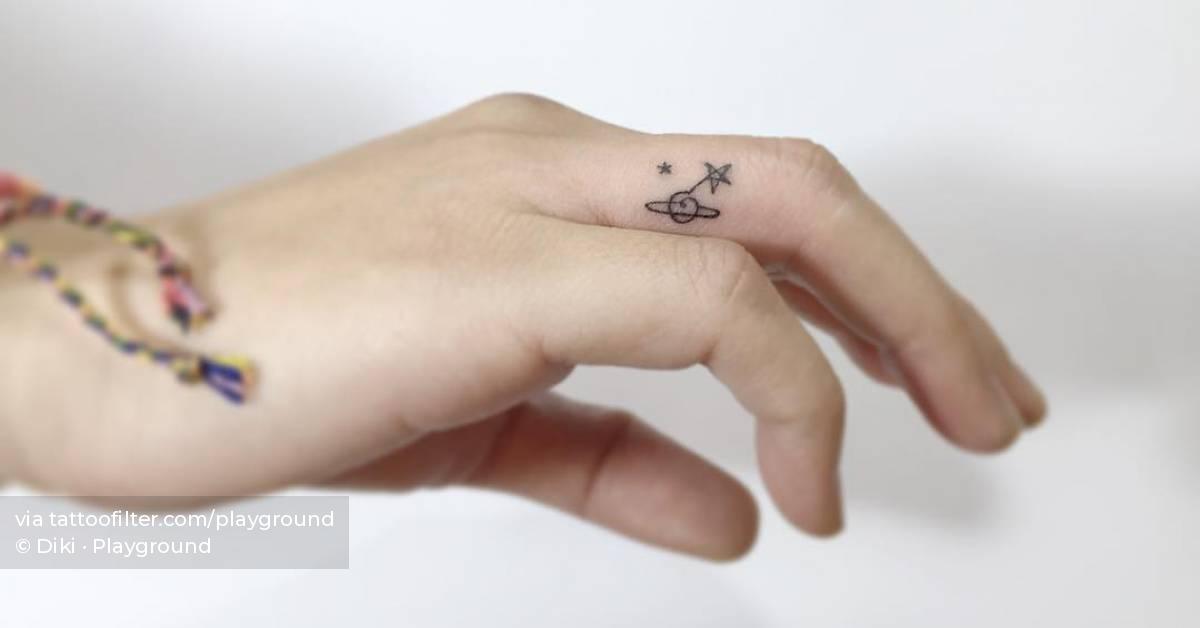 Saturn and stars tattoo located on the finger,