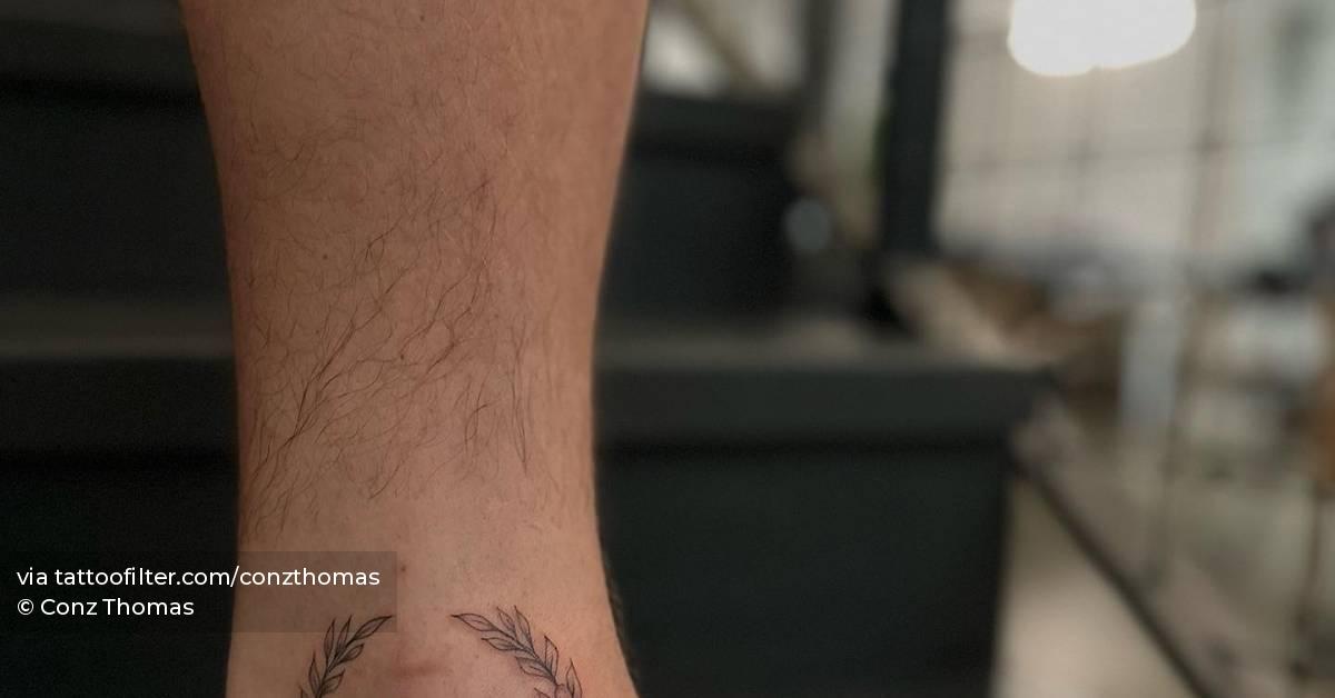 Fine line style laurel wreath tattoo done on the ankle.