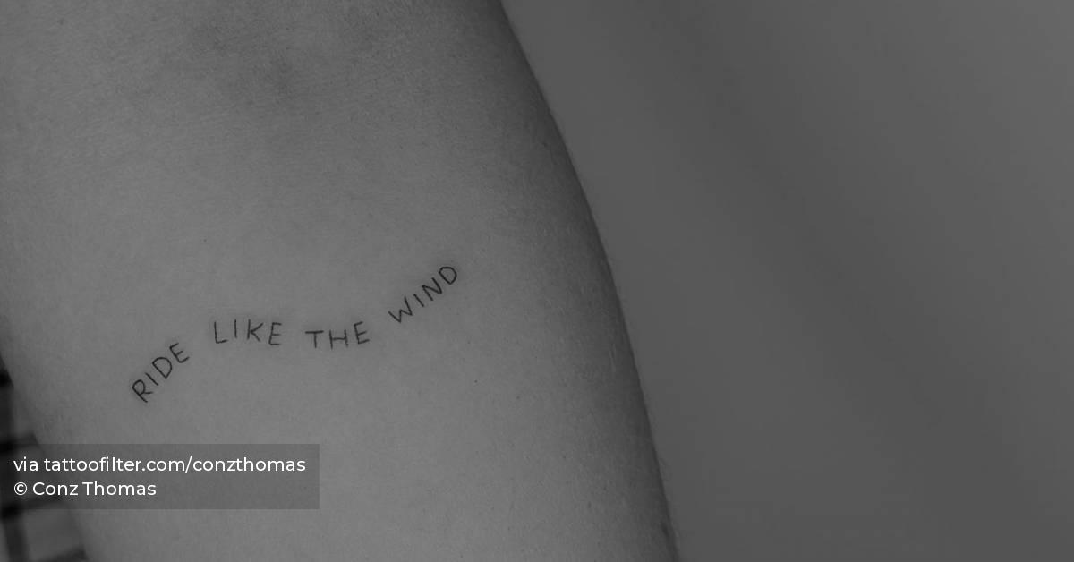 "Ride like the wind" lettering tattoo located on the