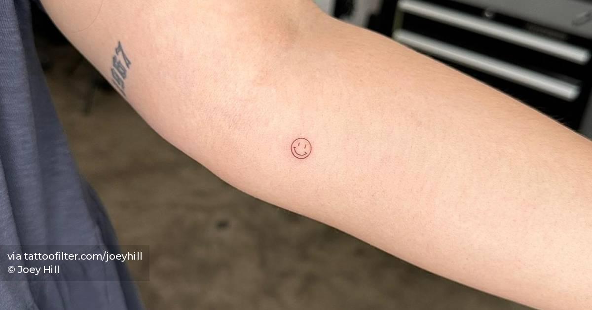 Tiny minimalistic smiley face tattoo done on the inner