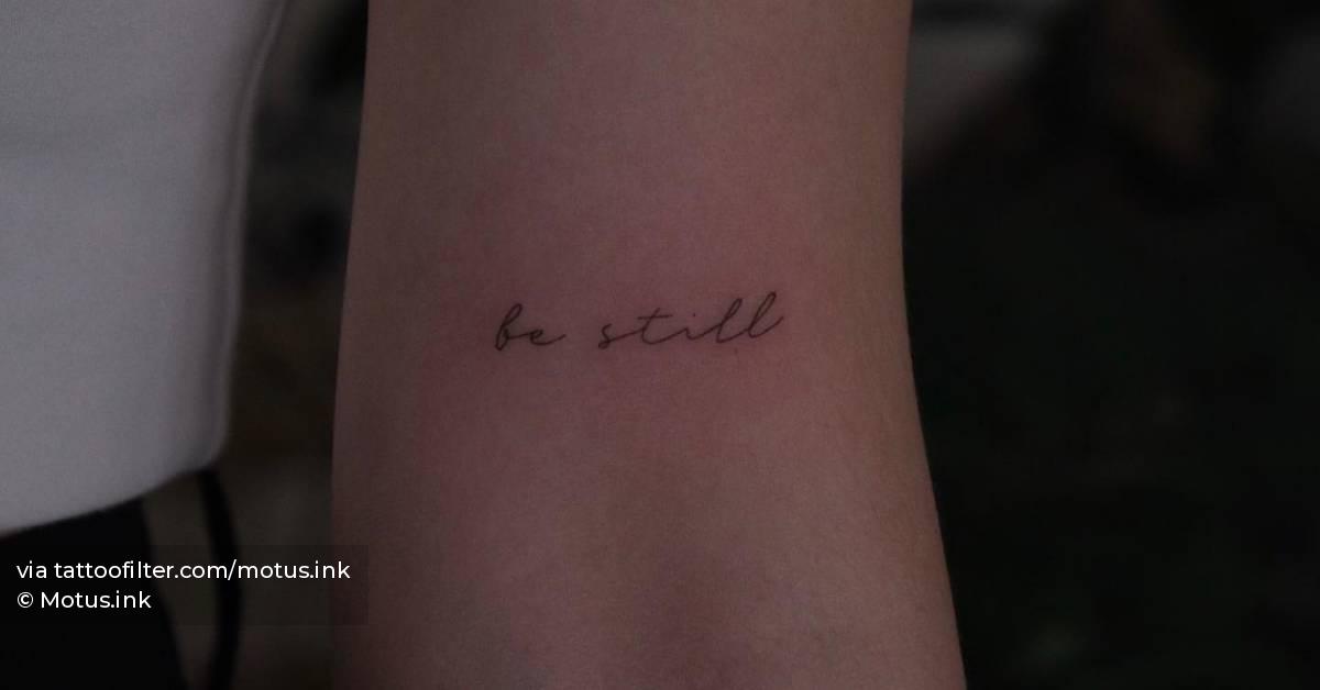 "Be still" lettering tattoo handwritten on the bicep.
