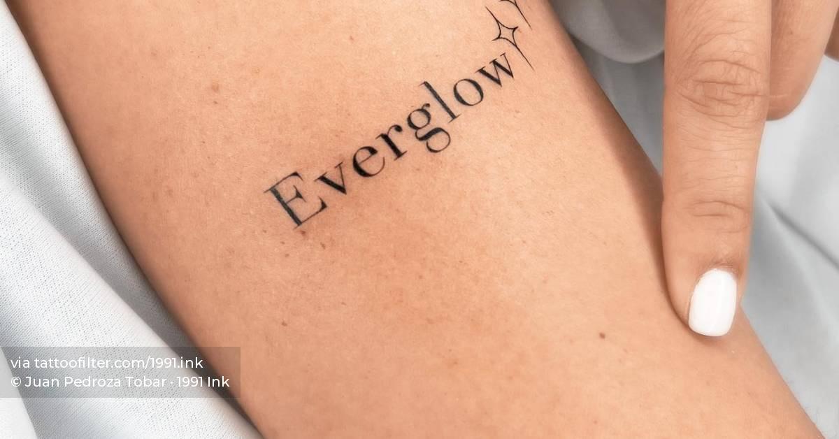 "Everglow" lettering tattoo located on the upper arm.