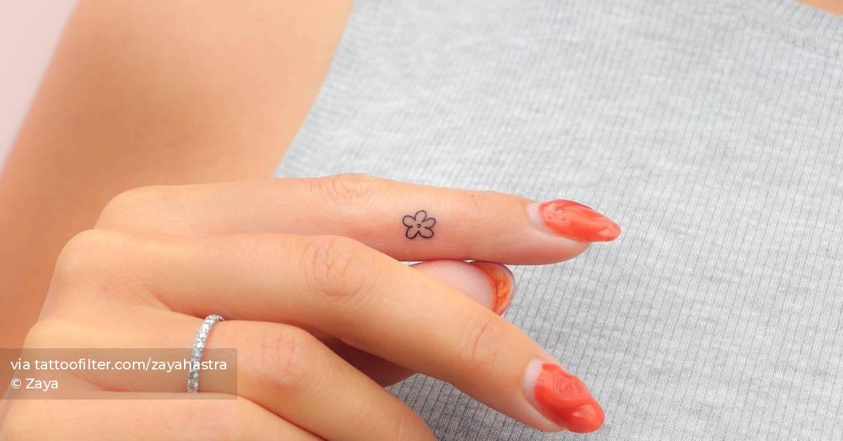 Super tiny minimalistic flower tattoo located on the