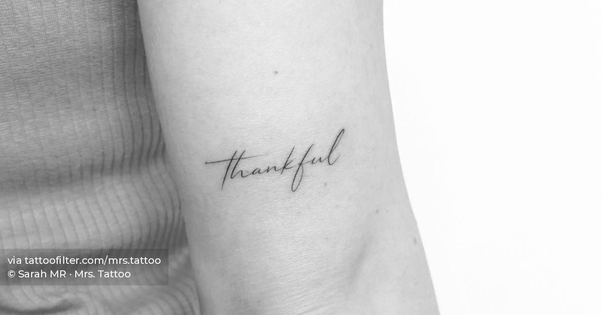 Tattoo of the word "thankful" handwritten on the