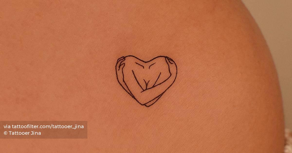 Minimalistic self hug tattoo placed on the shoulder.