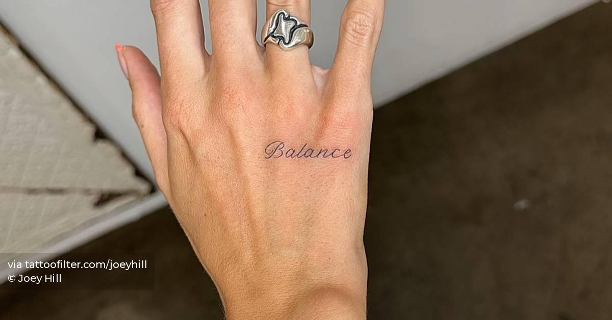Tattoo of the word "balance" placed on the hand.