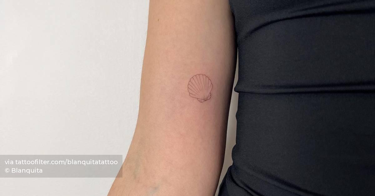 Fine line style scallop shell tattoo located on the