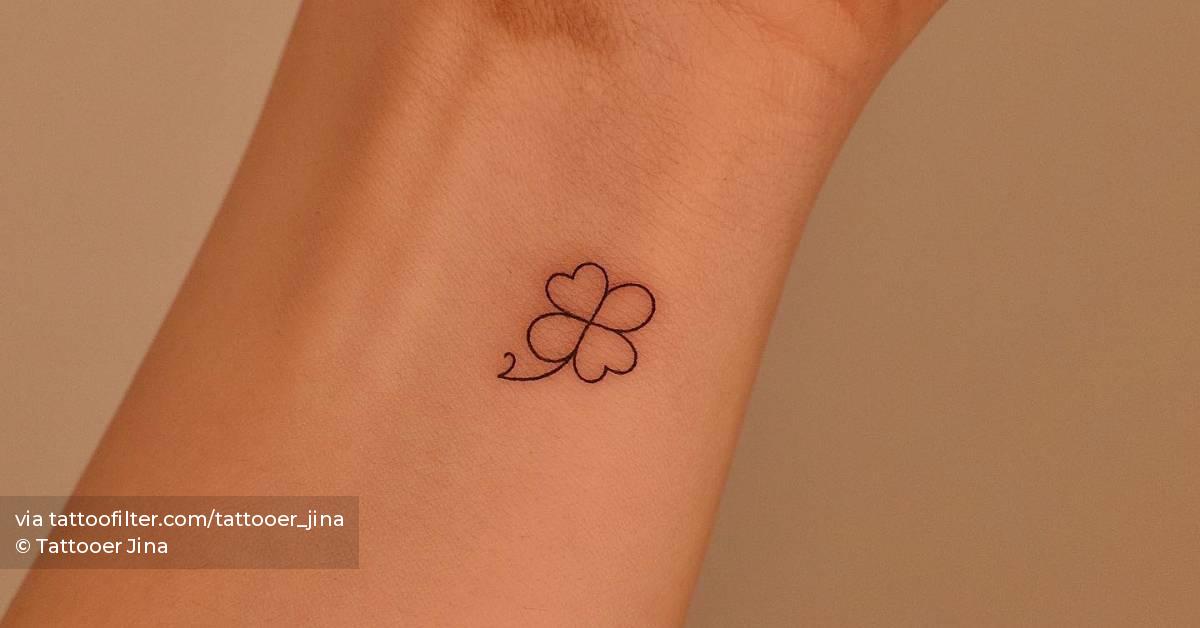 Fine line style four leaf clover tattoo located on the