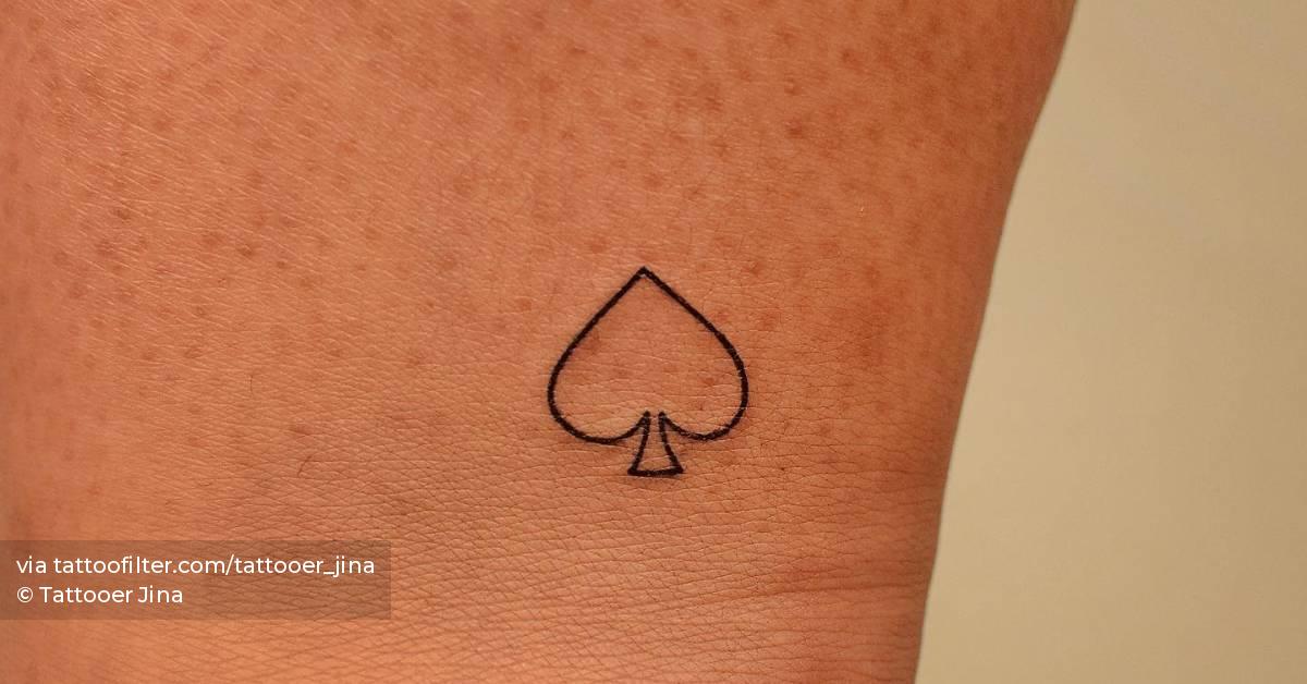 Minimalistic style spade suit tattoo placed on the