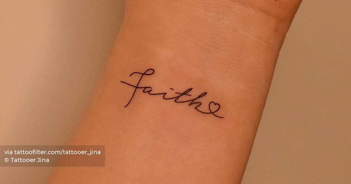 Tattoo of the word "faith" handwritten on the wrist.