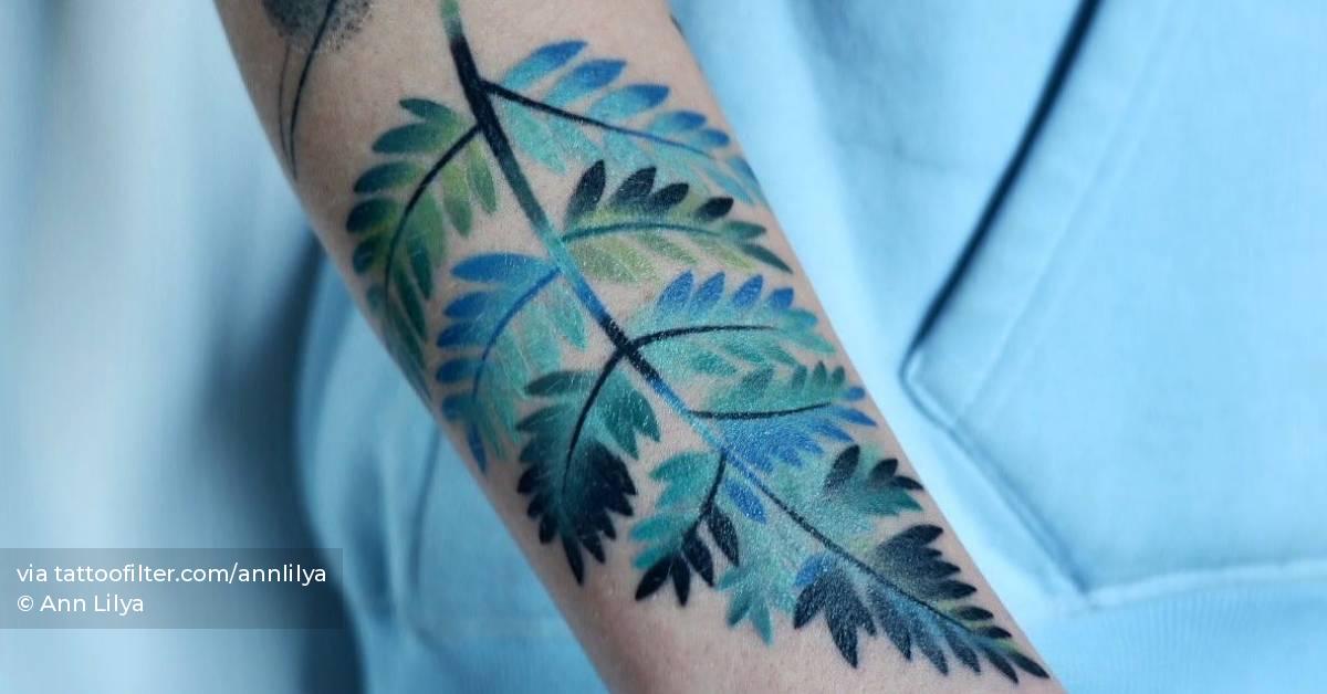 Watercolor style fern frond tattoo located on the