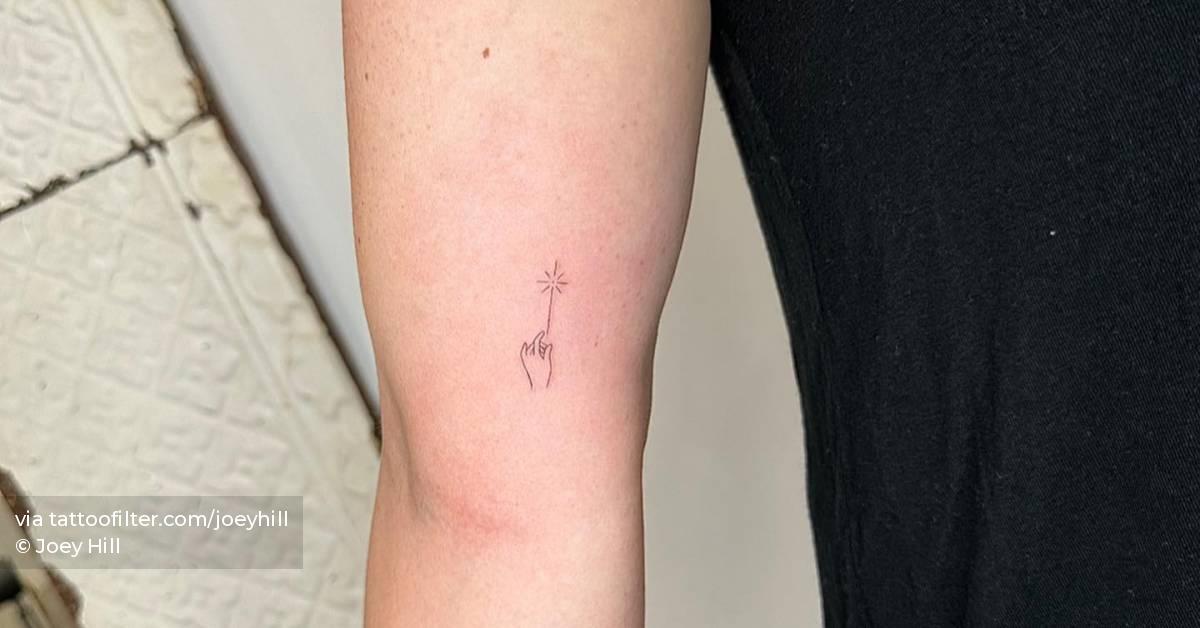 Hand and star tattooed on the inner arm, fine line