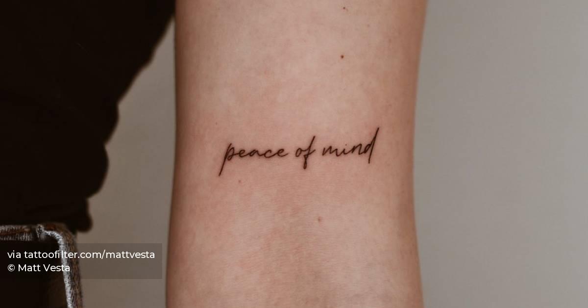 Tattoo that says "peace of mind" handwritten on the