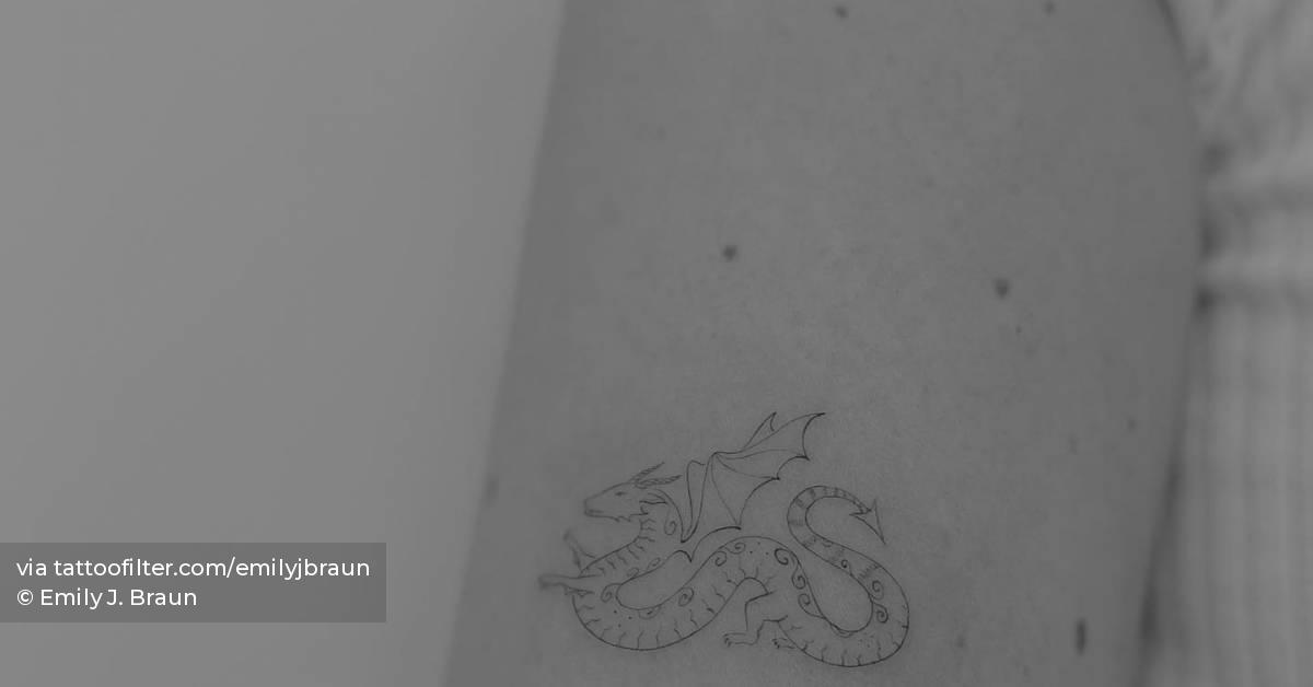 Fine line dragon tattoo located on the upper arm.