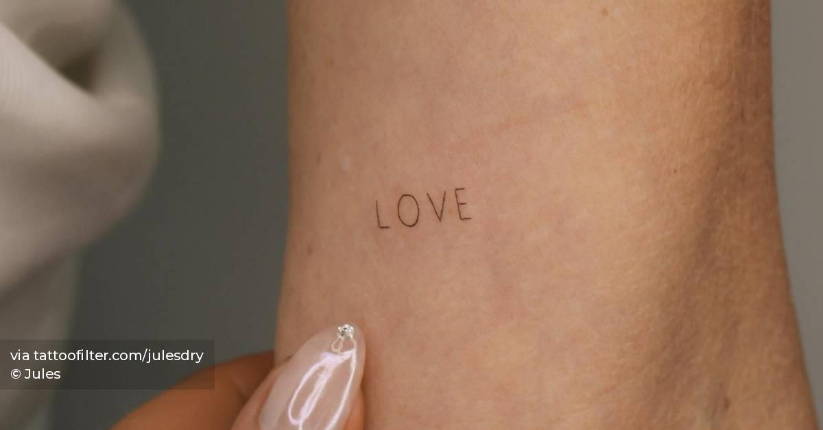 Delicate tattoo of the word "love" located on the inner