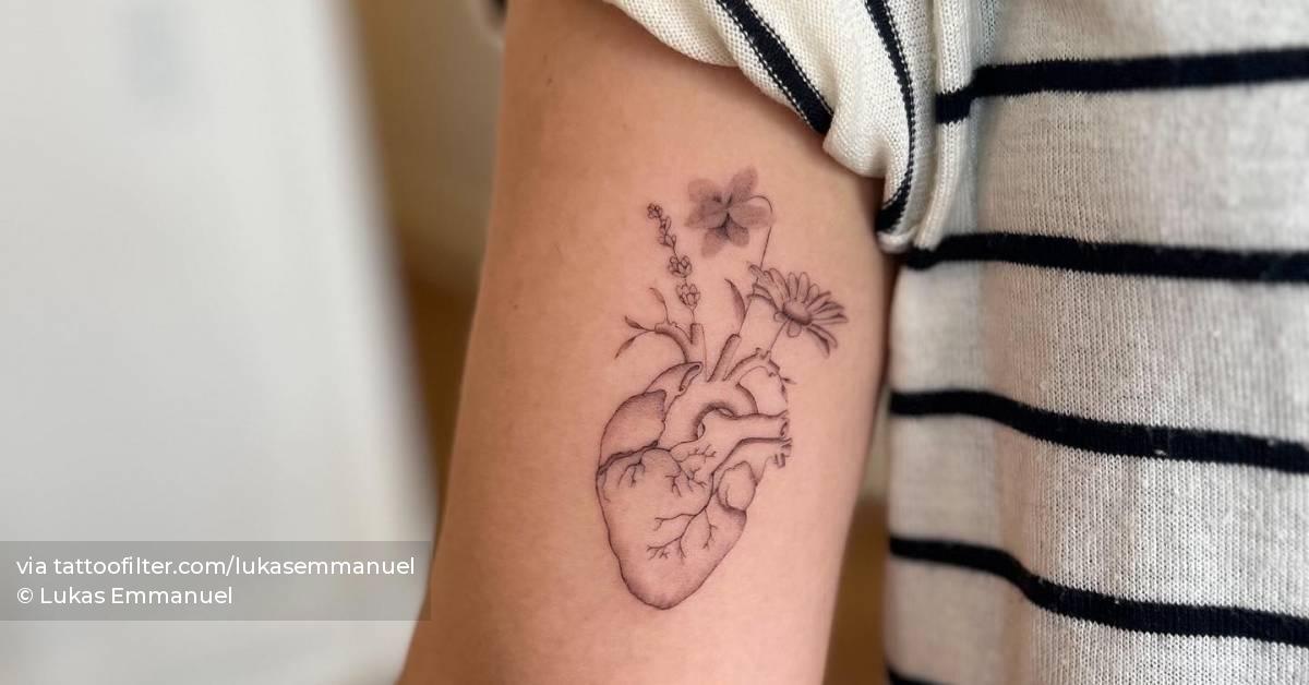 Single needle anatomical heart with flowers tattooed on