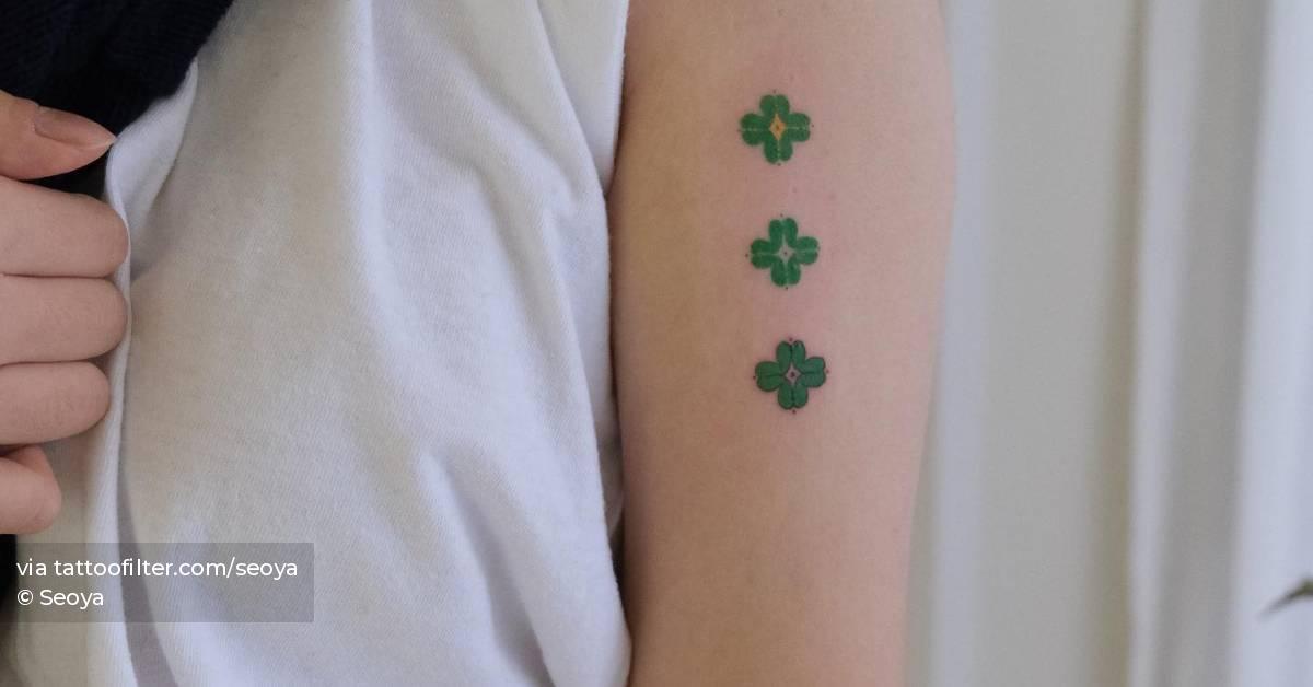 Four leaf clovers tattooed the upper arm, watercolor