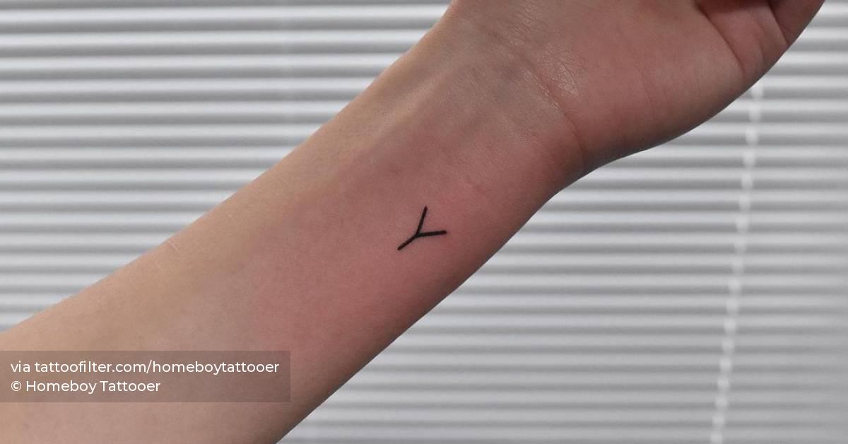 Minimalist letter "Y" tattoo on the wrist.