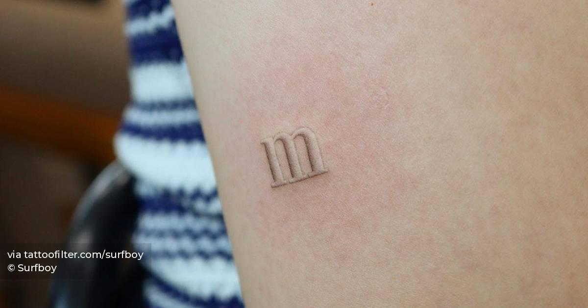 Han poked letter "M" tattoo located on the inner arm.