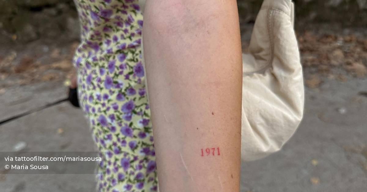 "1971" in red ink tattooed on the inner forearm