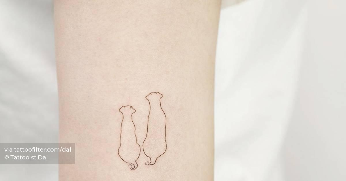 Fine line dogs tattoo located on the upper arm,