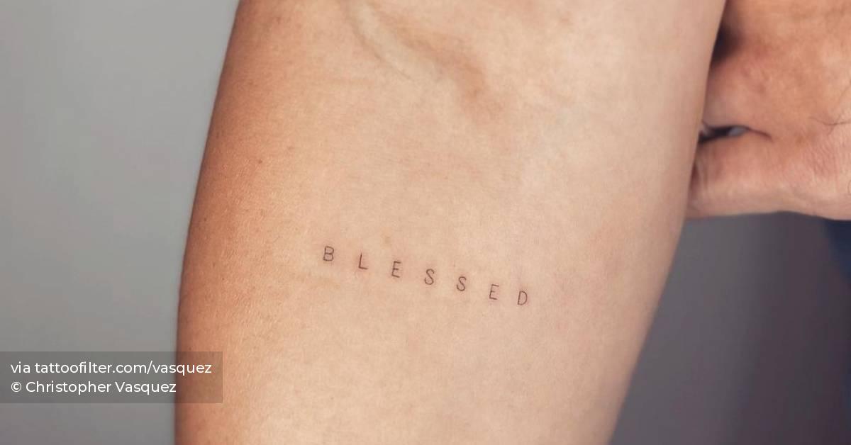 Tattoo of the word "blessed" located on the inner