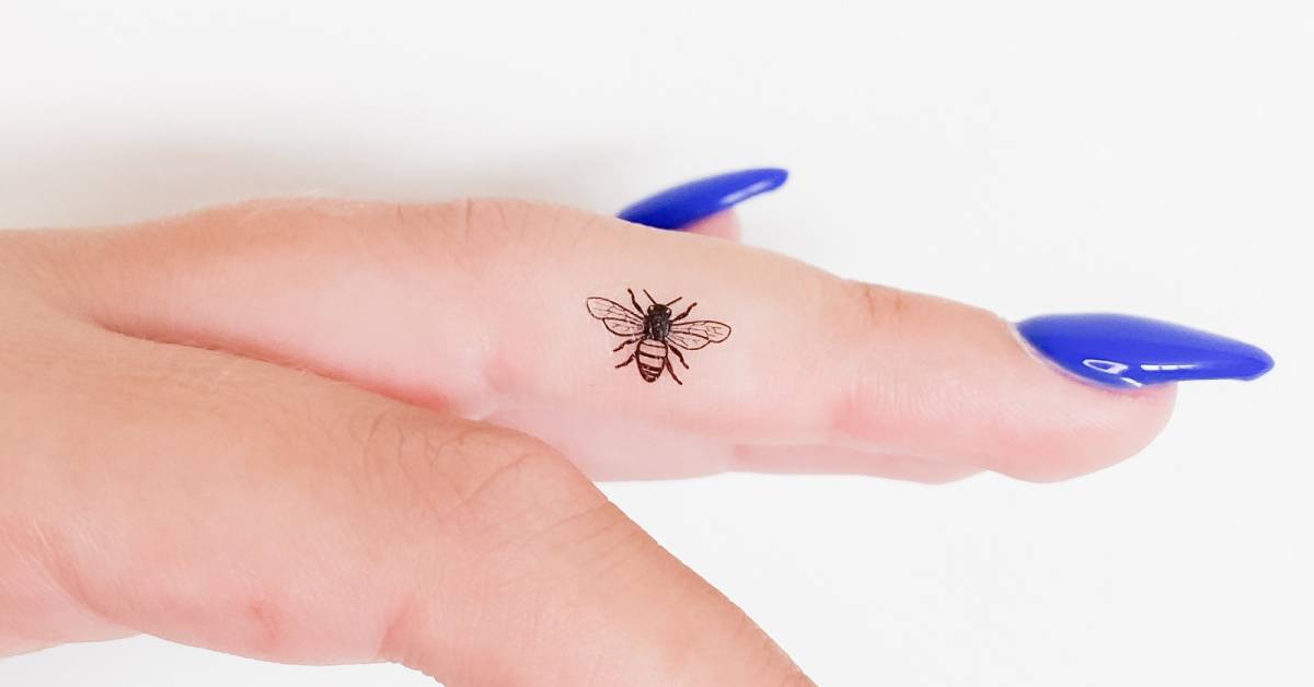 Tiny little bee temporary tattoo placed on the finger.