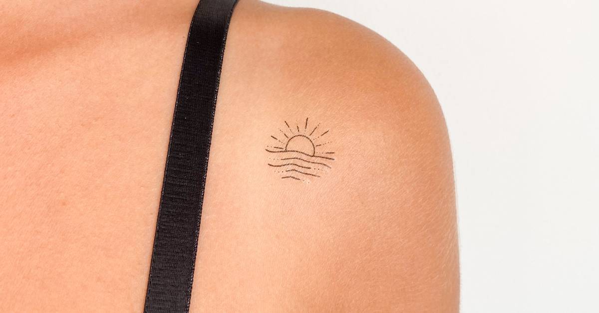 Fine line beach sunset tattoo located on the shoulder.