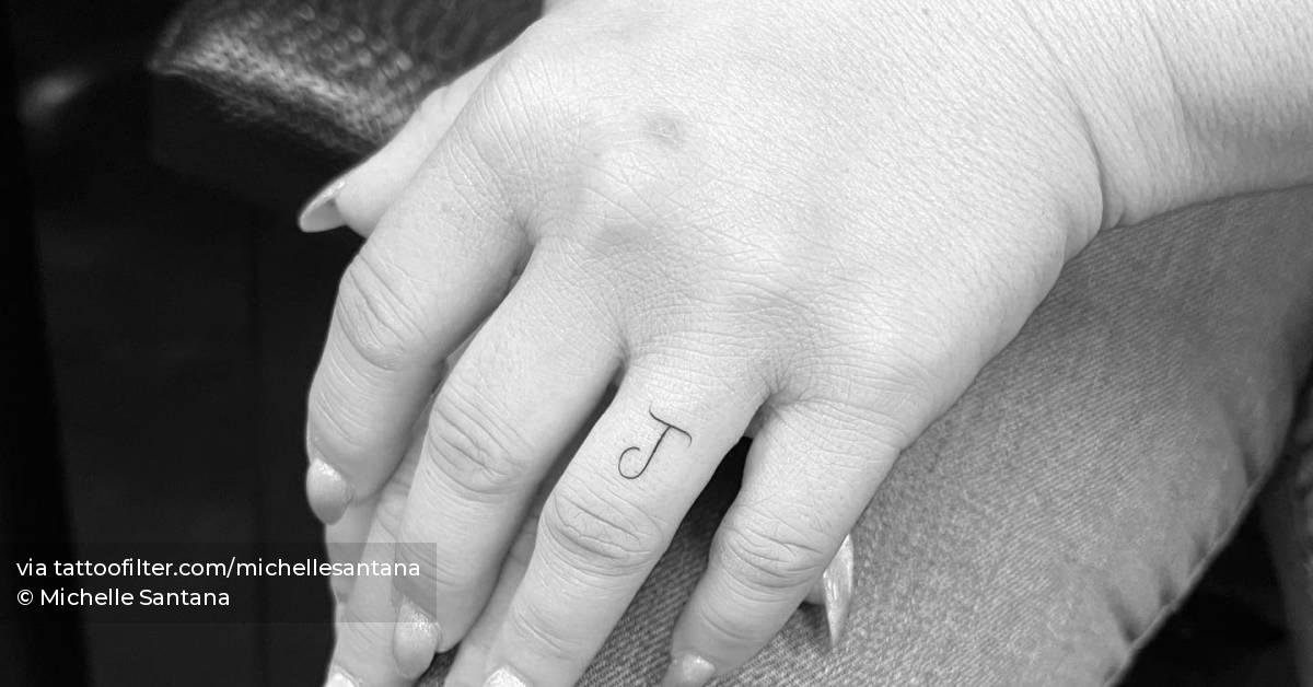 Tiny tattoo of the letter "J" located on the finger.