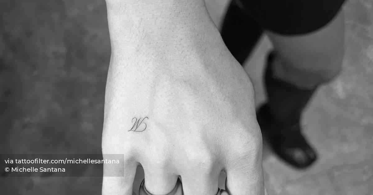 Delicate letter "M" tattoo located on the hand.