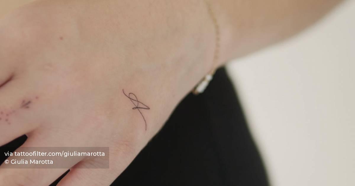 Tiny letter "A" tattoo located on the hand.