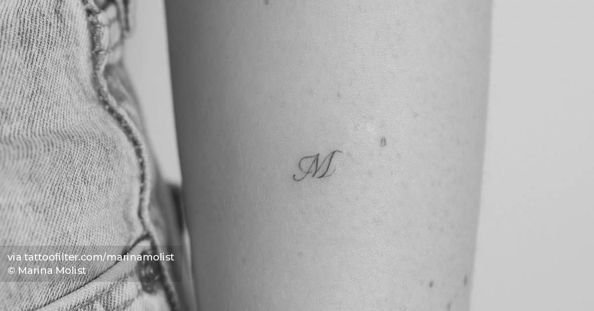 Minimalistic letter "M" tattoo done on the forearm.